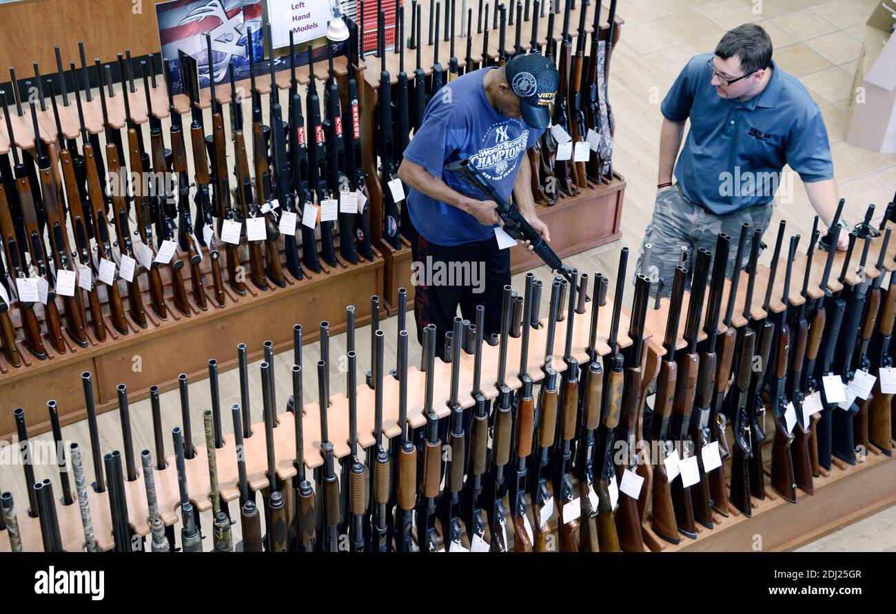 A sales representative helps a customer to choose a assault rifle in ...