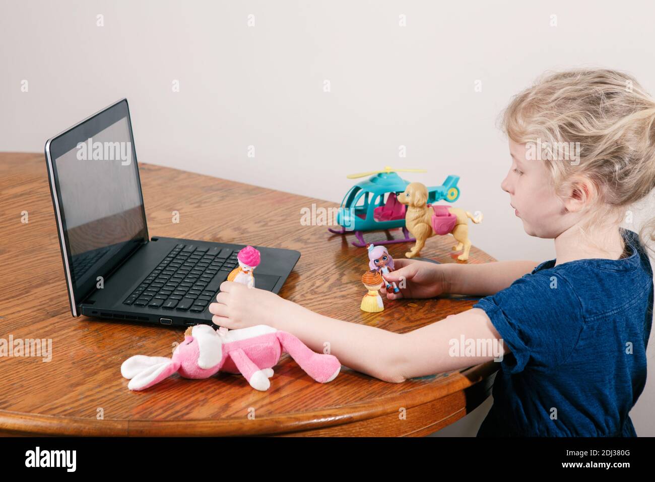 Cute adorable Caucasian girl playing toys with friends on video chat ...