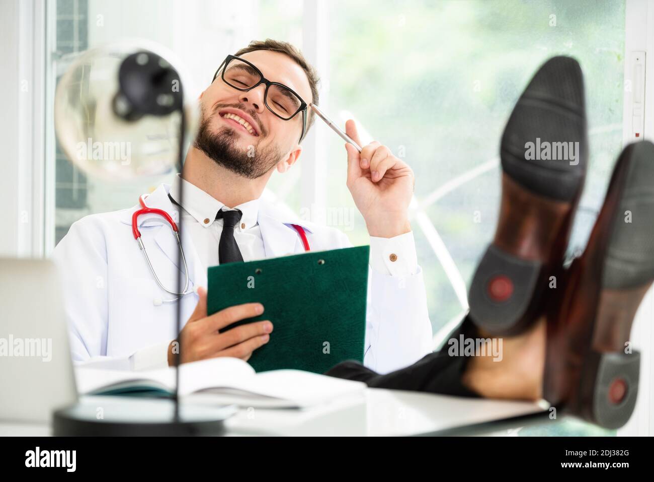 Friendly relaxed doctor feel happy at office table in the hospital ...