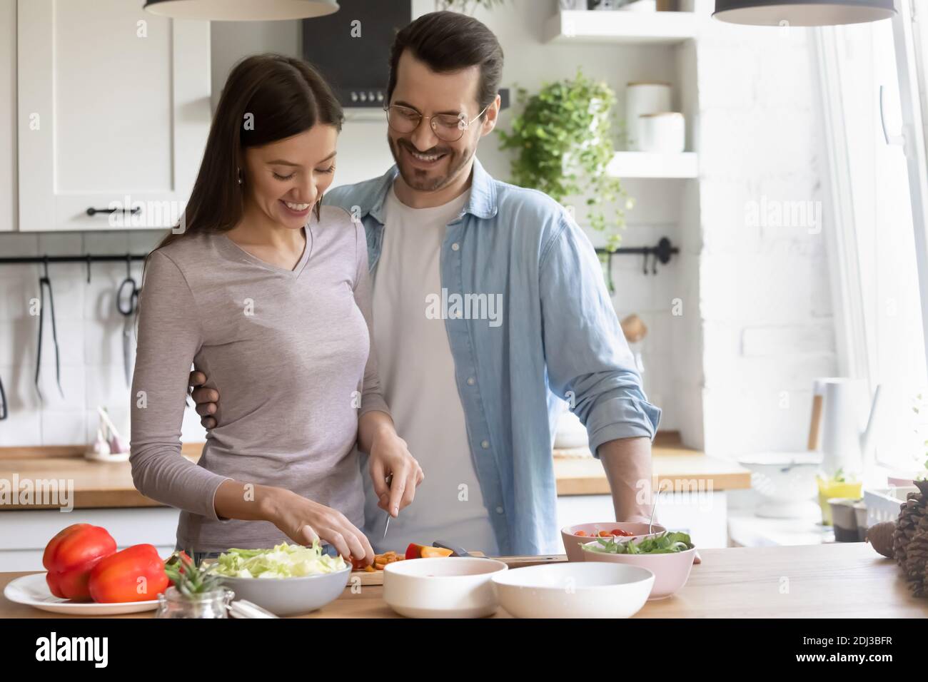 Happy young couple cooking healthy food together in kitchen Stock Photo ...