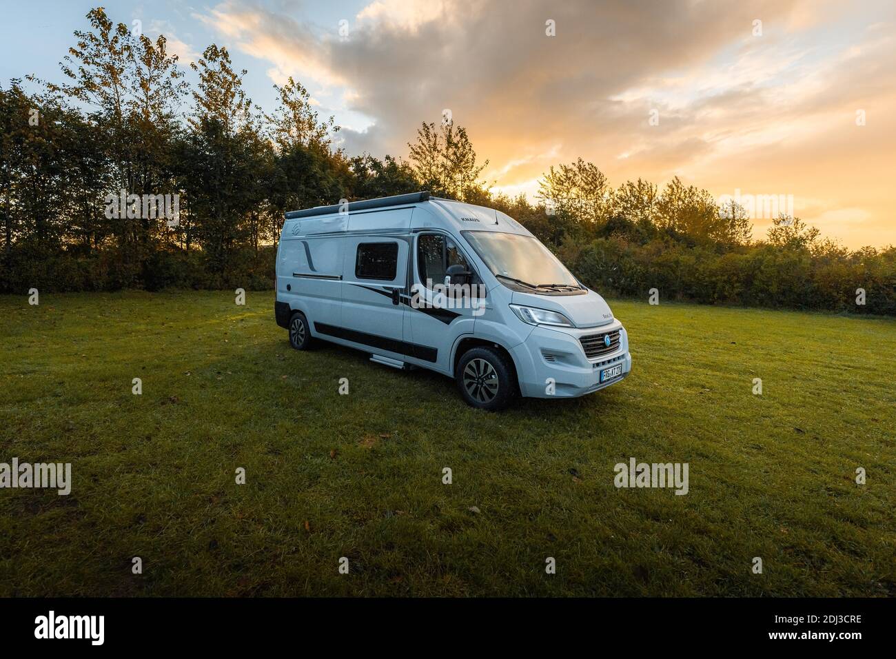 Campervan stands on the lawn of Uge Lystfiskeri og Camping at sunrise ...