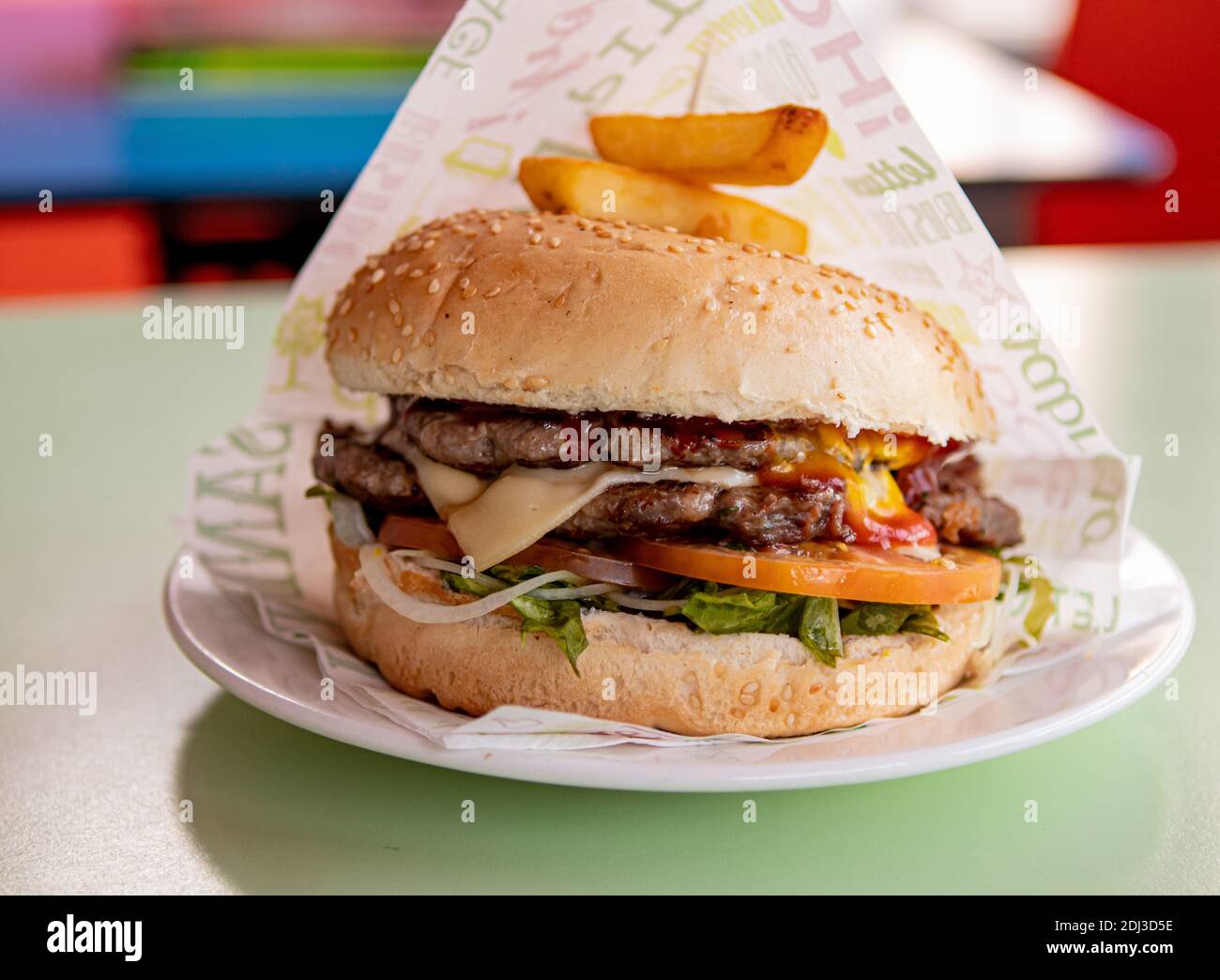 Juicy double cheeseburguer with bacon, tomato, salad and sauces. Close ...
