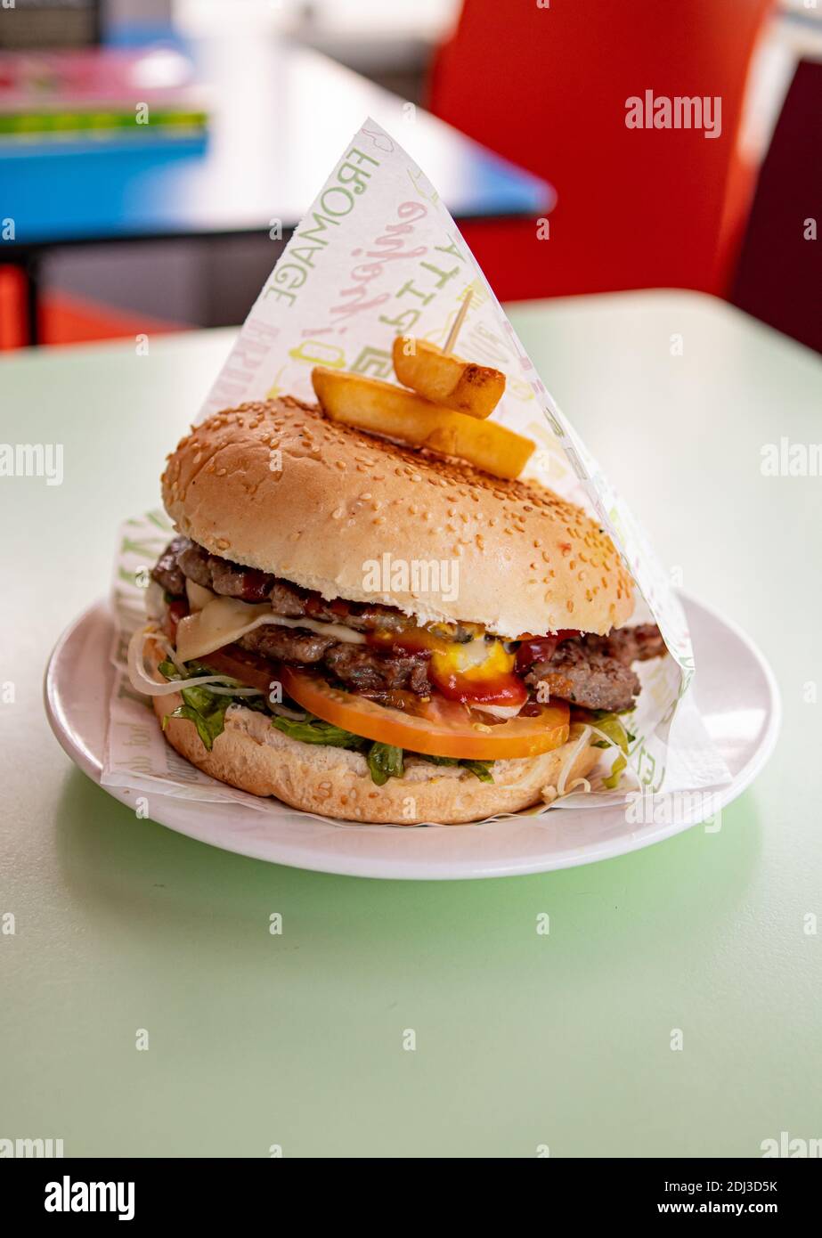 Juicy double cheeseburguer with bacon, tomato, salad and sauces ...