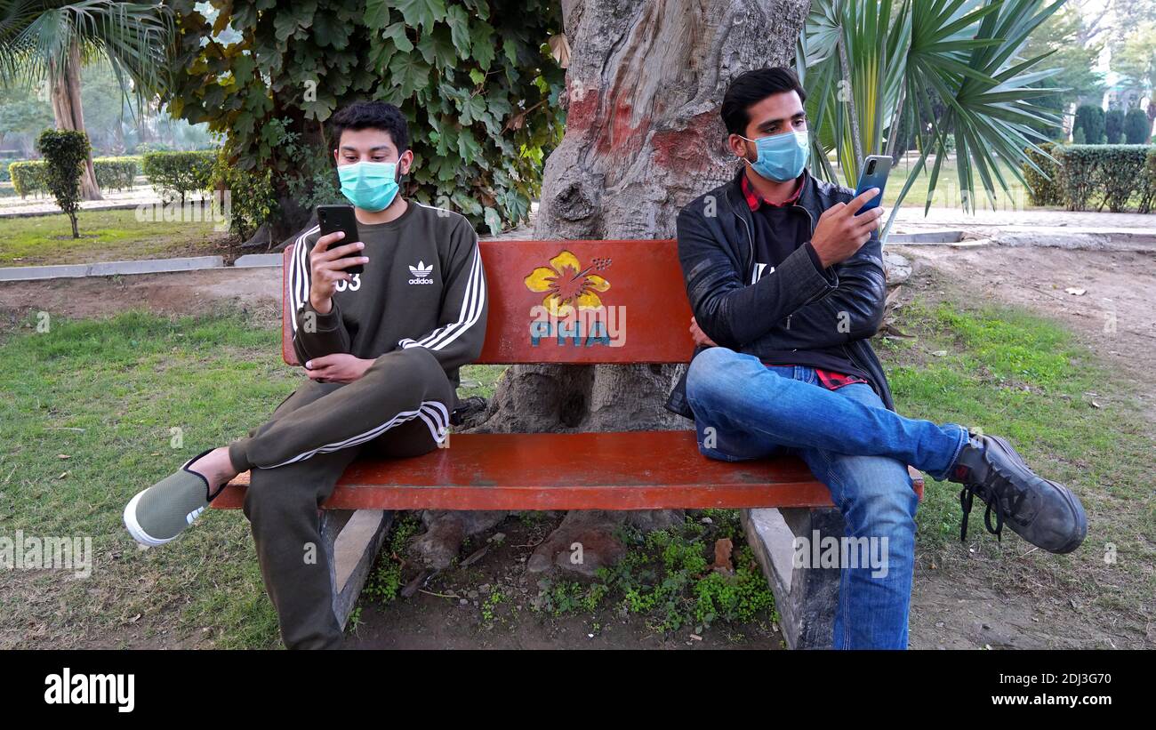 Friends sitting on bench Wearing Face Mask Stock Photo - Alamy