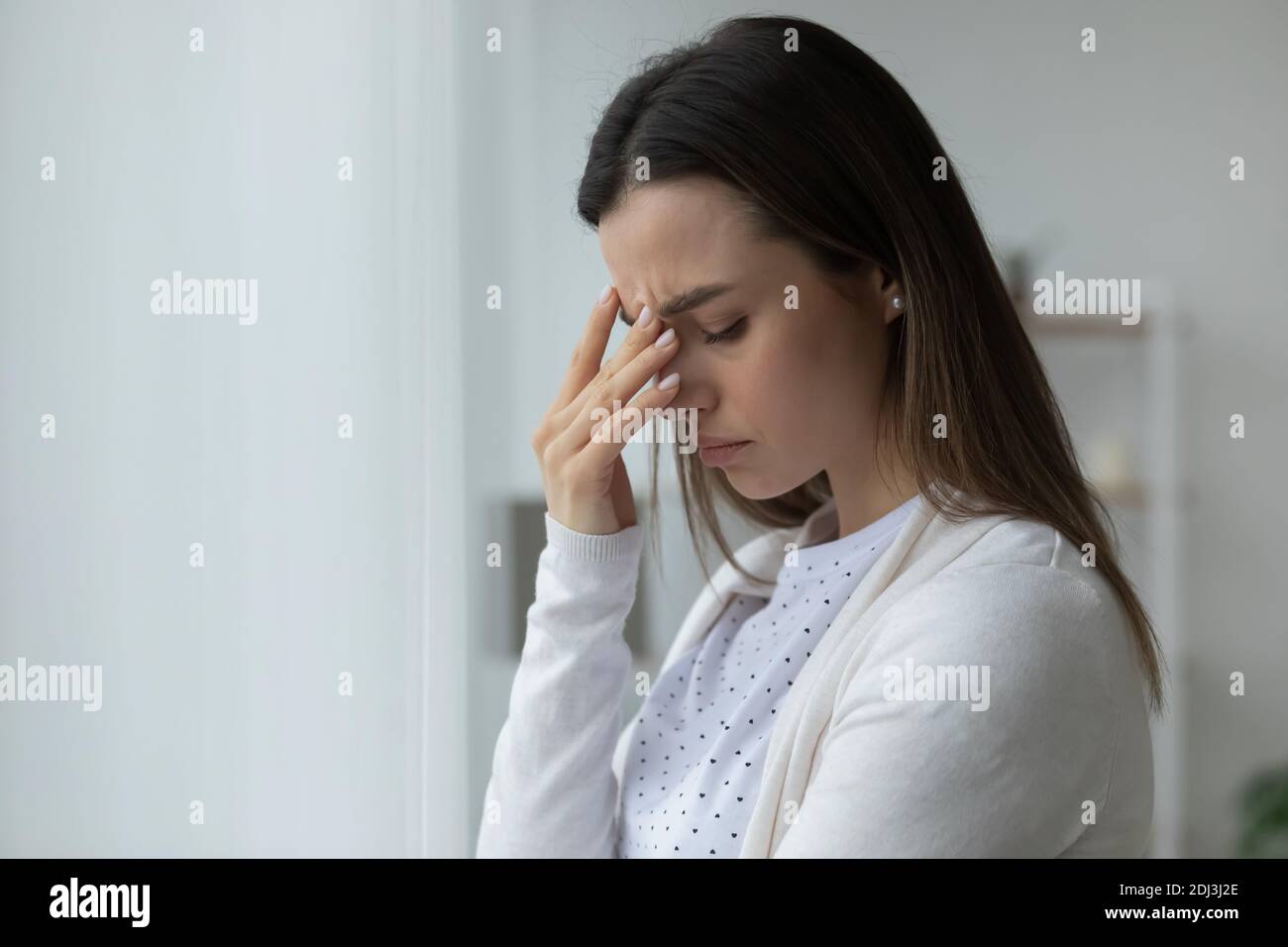 Close up unhappy stressed young woman standing near window Stock Photo ...