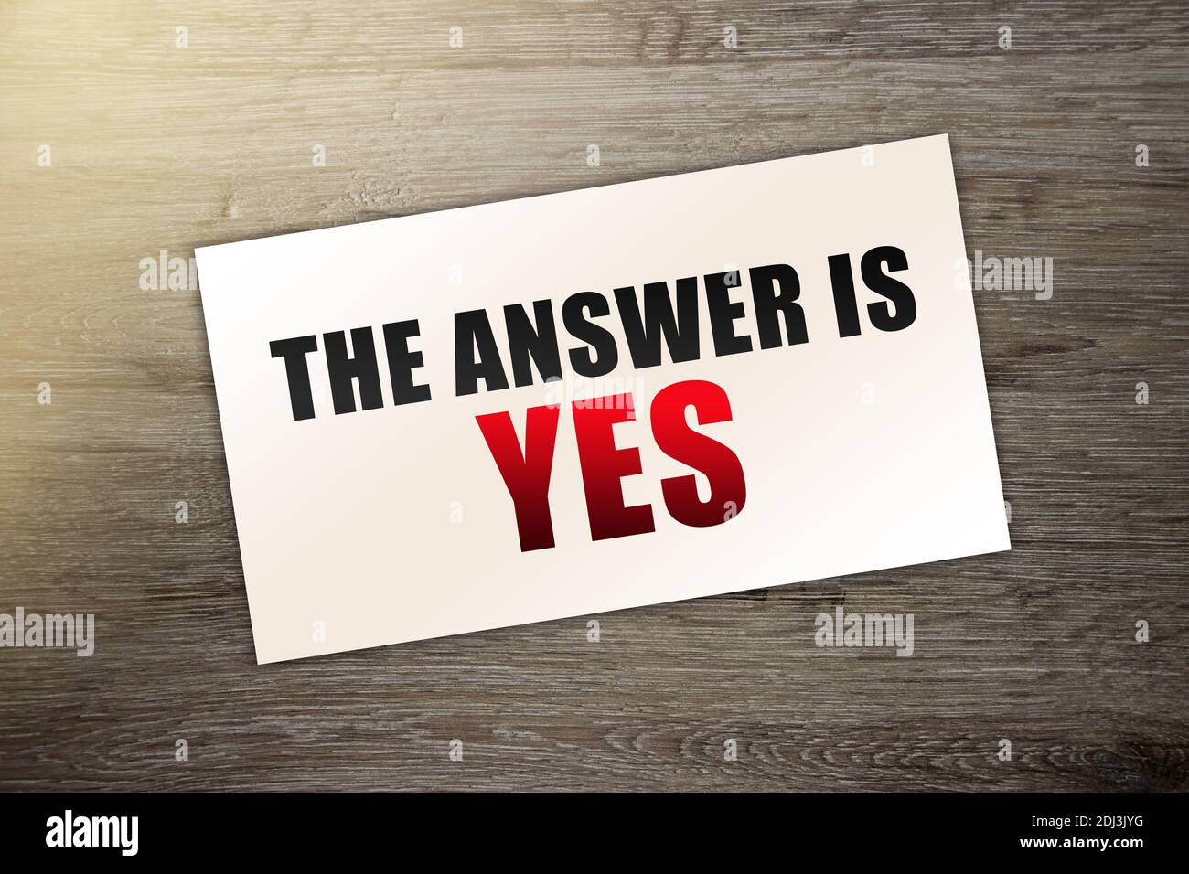 the words Answer is Yes on the card on wooden table. Positive solution ...