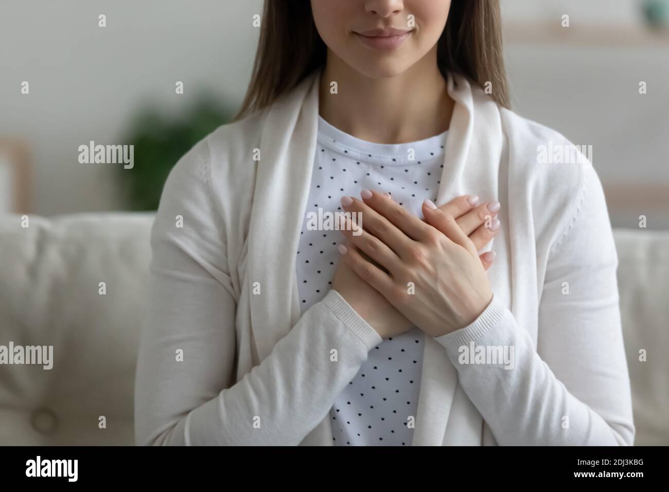 Close up wishful peaceful young woman holding hands on chest Stock ...