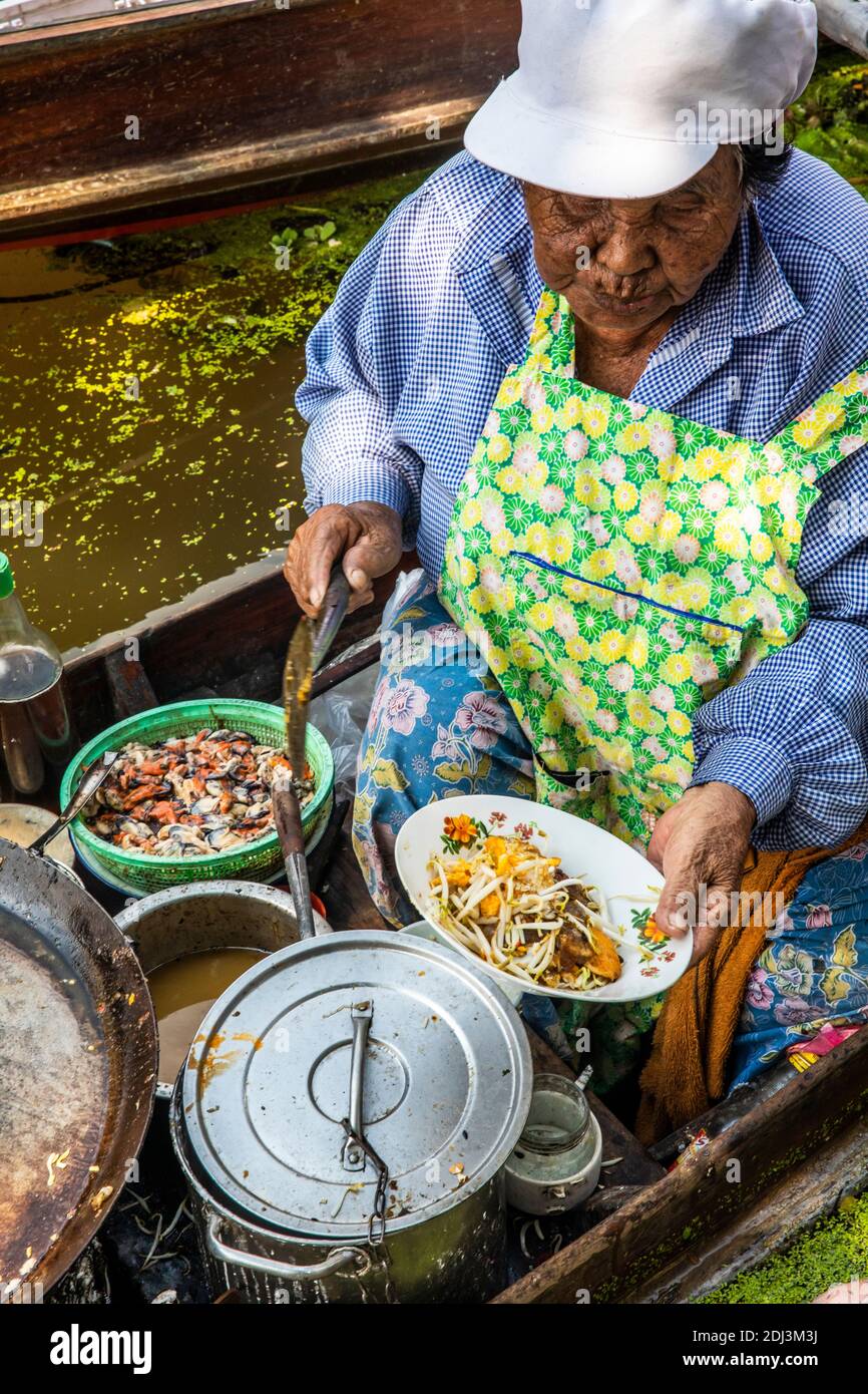 A woman merchant has a full food operation on her san pan in the ...
