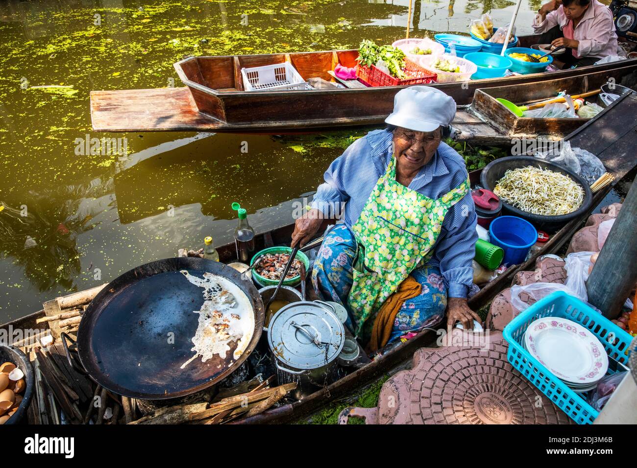 A woman merchant has a full food operation on her san pan in the ...