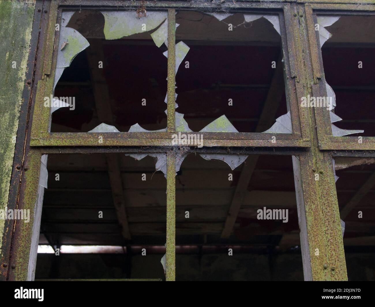 Broken windows with jagged glass in derelict old abandoned building ...