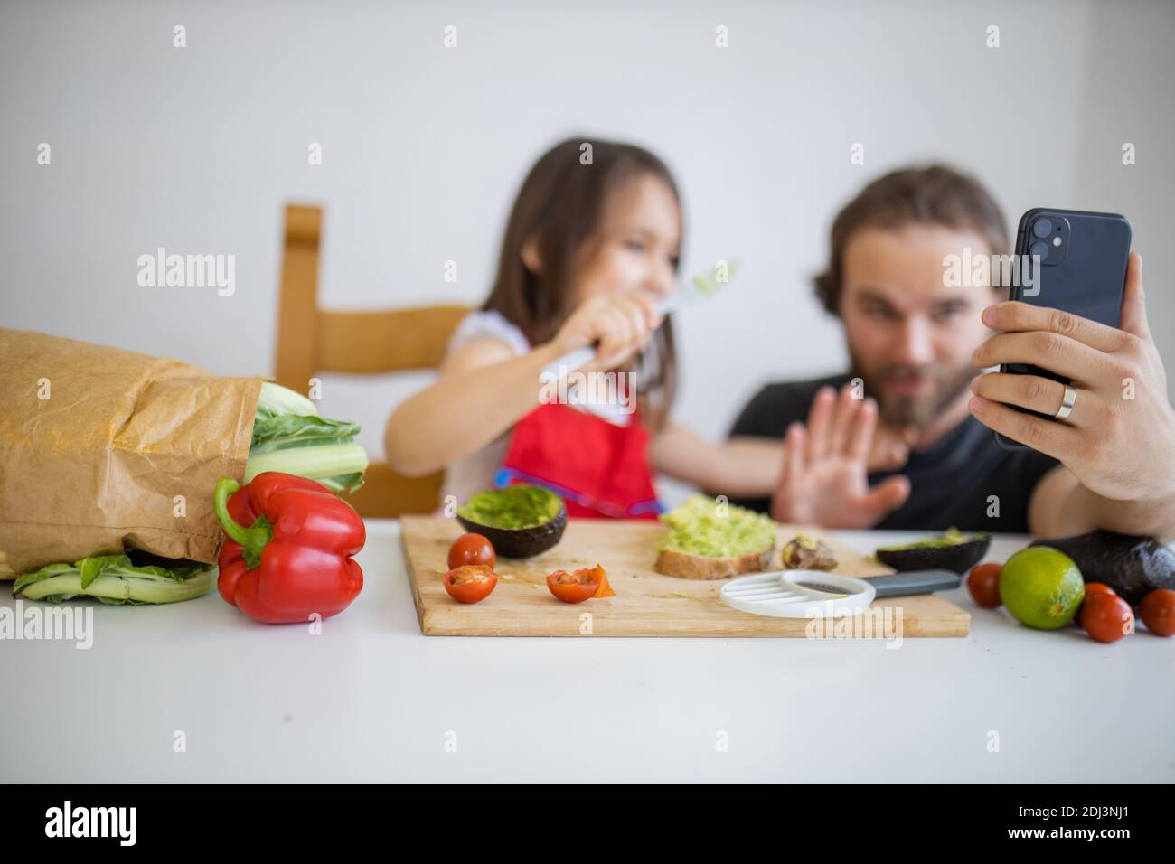 Father and daughter taking a selfie while making avocado toast Stock ...