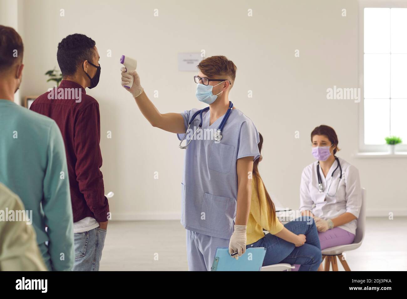 Medical worker measuring man's temperature using non-contact digital ... Medical worker measuring man's temperature using non-contact digital ...