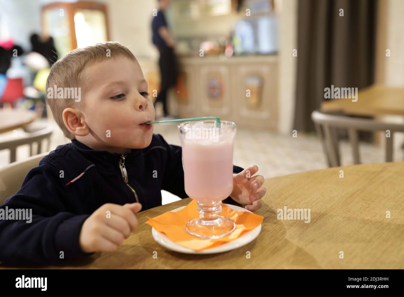 Child has milkshake at table in cafe Stock Photo - Alamy