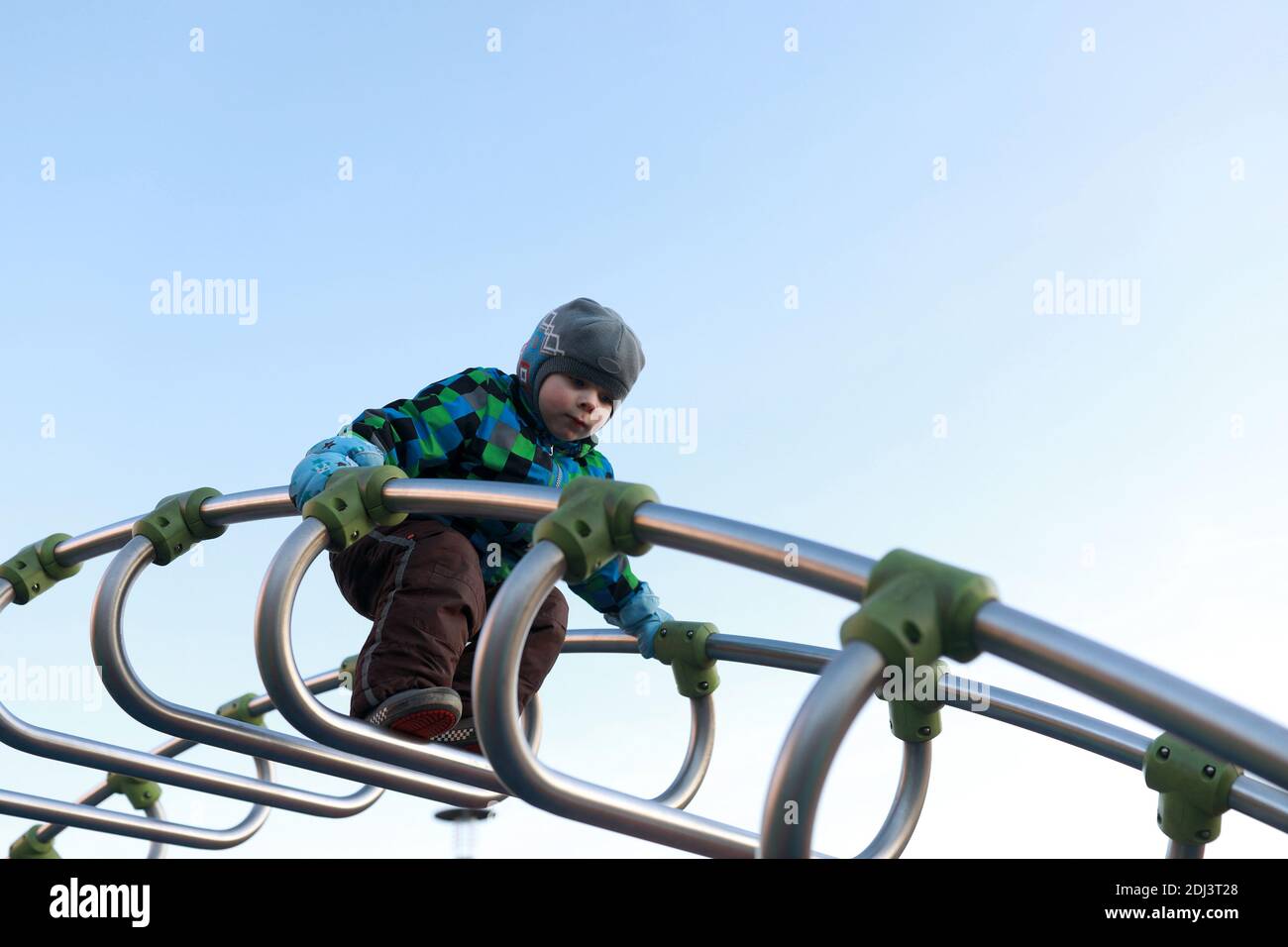 Kid climbing metal bridge at playground in spring Stock Photo - Alamy