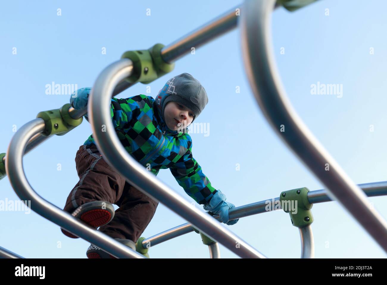 Boy climbing metal bridge at playground in spring Stock Photo - Alamy