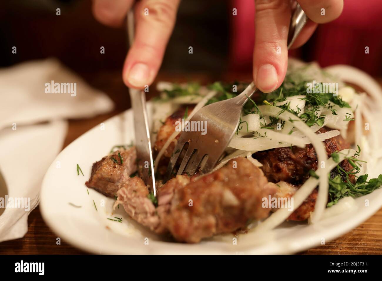 Person eating kebab at table in a restaurant Stock Photo - Alamy