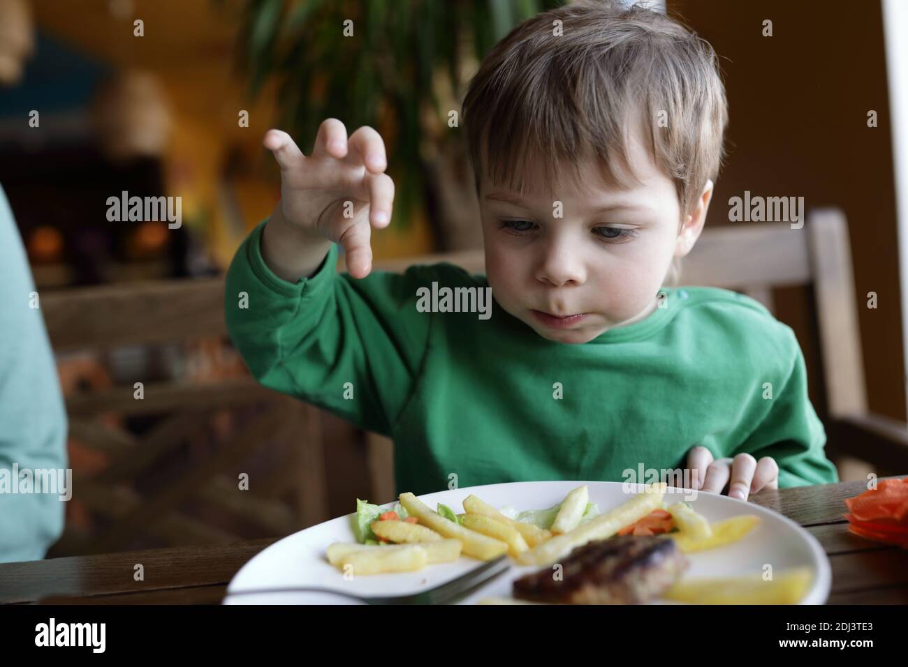 Boy eating french fries hi-res stock photography and images - Alamy