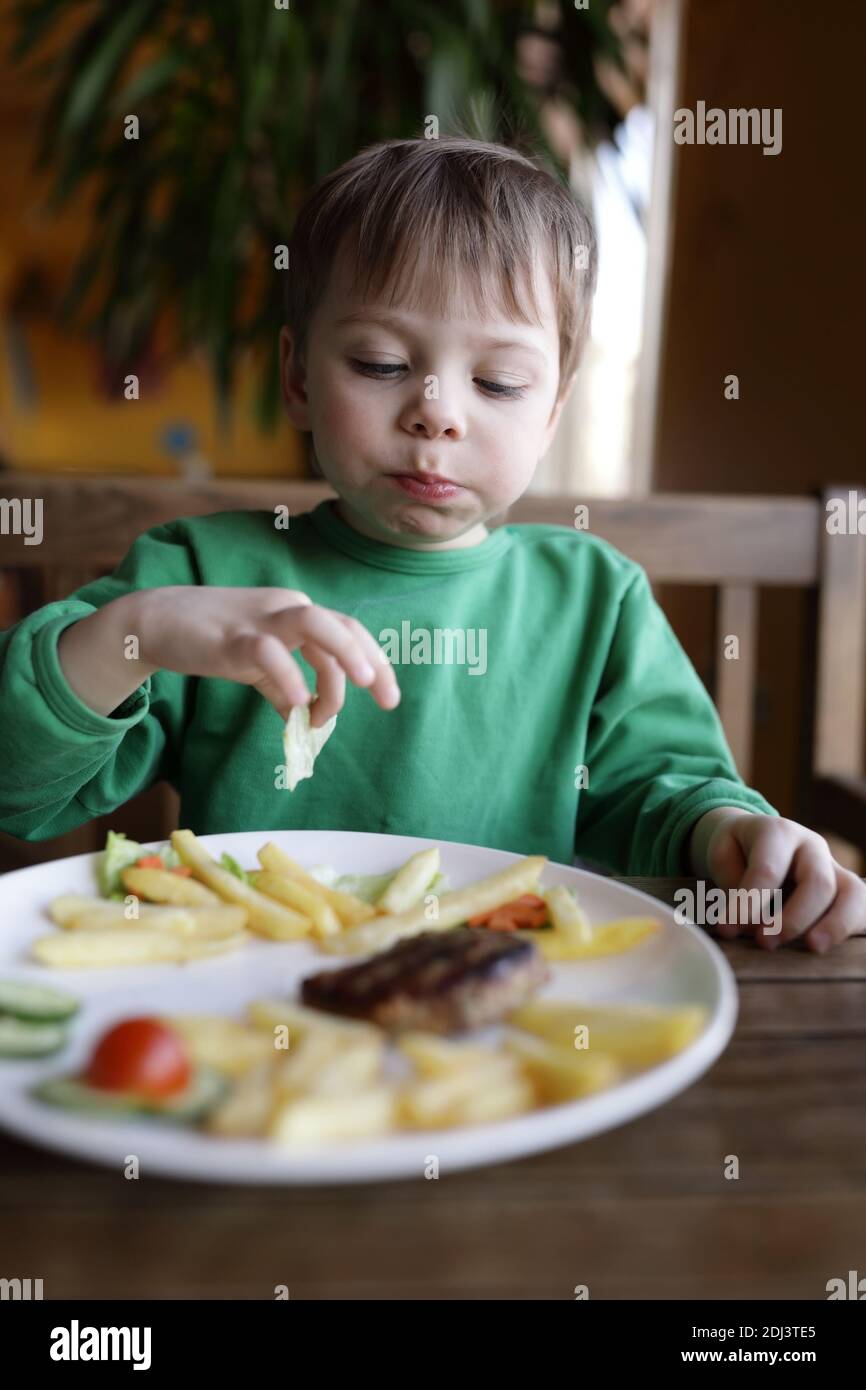 Child eating french fries in a cafe Stock Photo - Alamy