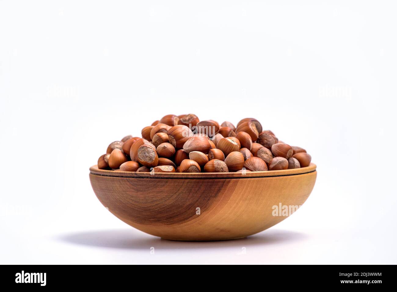 Hazelnuts in a wooden bowl on white background. Solid ripe Hazelnuts ...