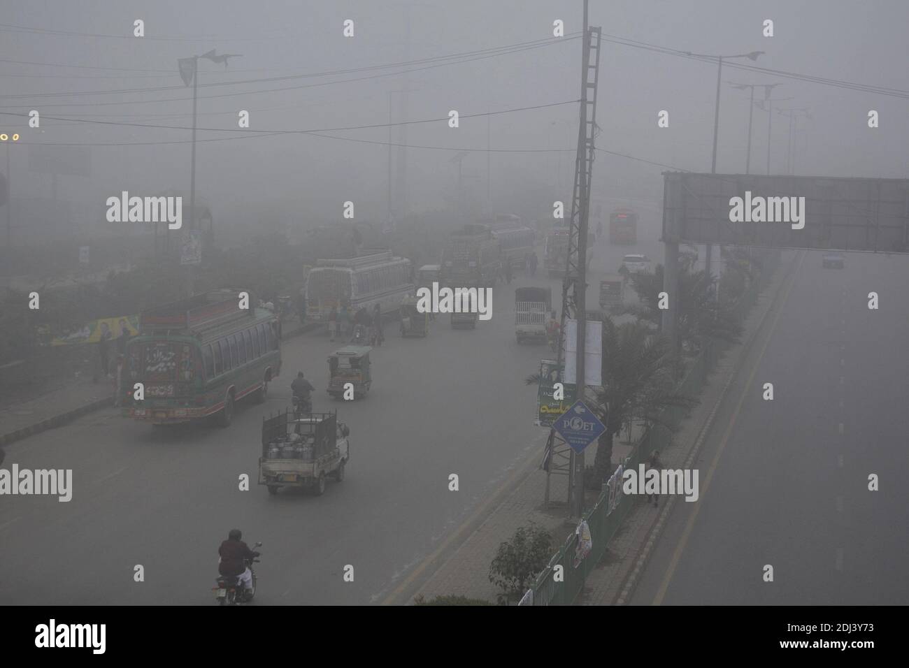 Lahore. 13th Dec, 2020. Vehicles move on a road in dense fog in ...