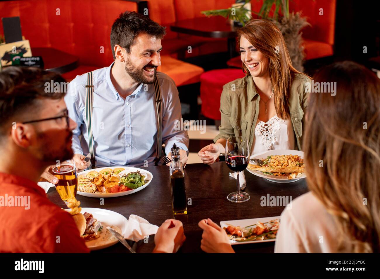 Group of young people having dinner in the restaurant Stock Photo - Alamy