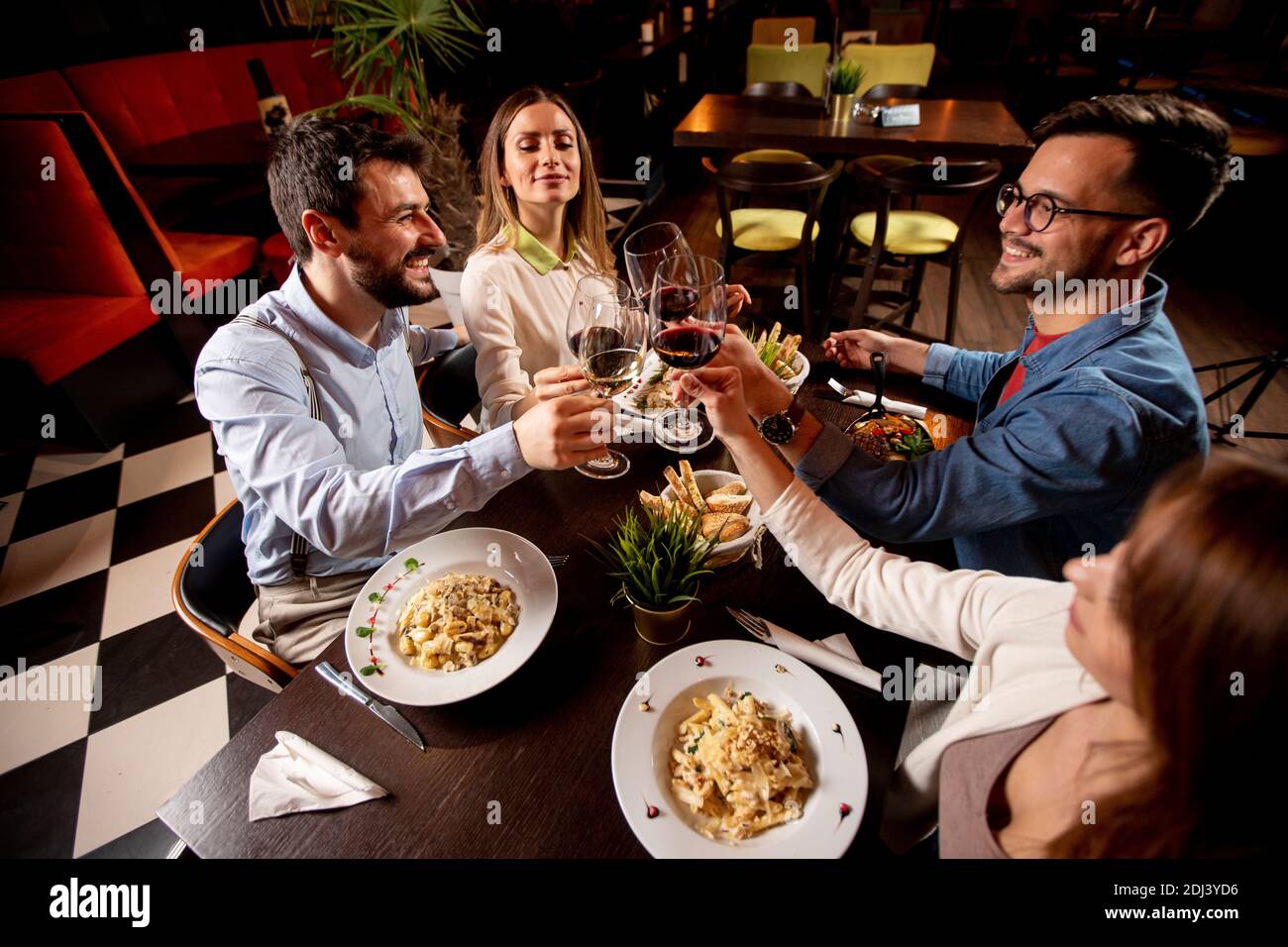 Group of young people having dinner in the restaurant Stock Photo - Alamy