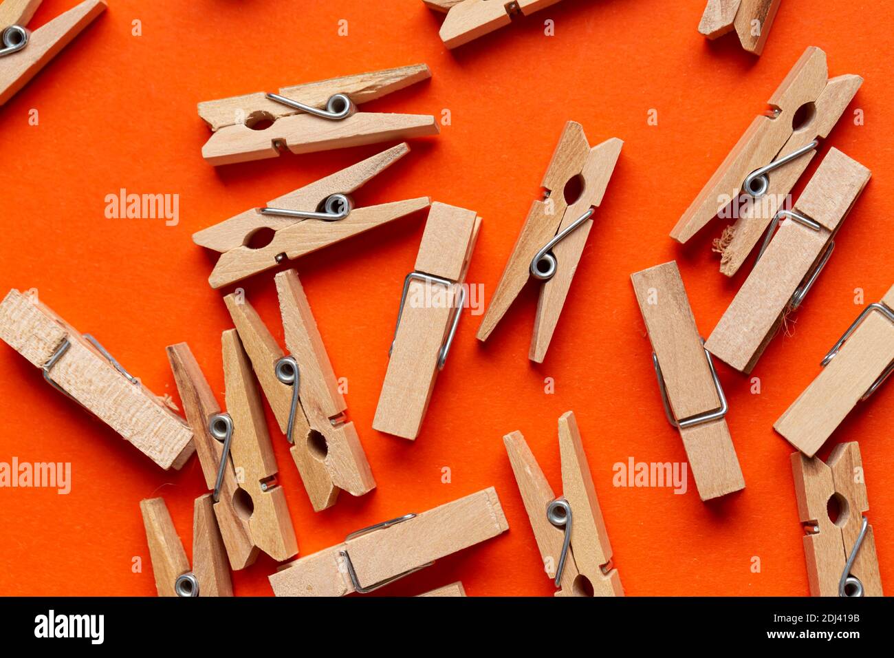 Many wooden clothespin on orange background. Top view Stock Photo - Alamy