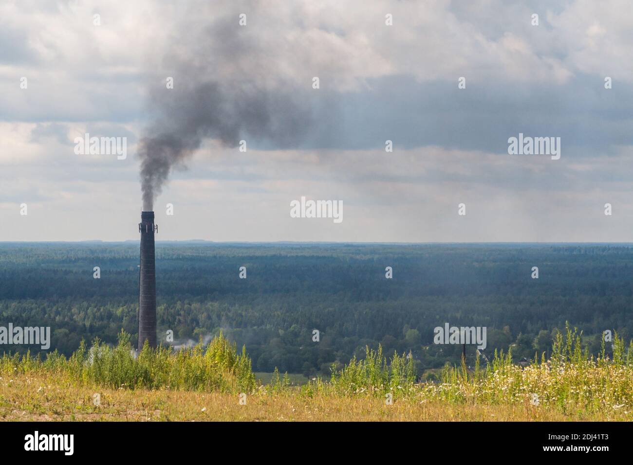 A grassy landscape with rising smoke - air pollution and environmental ...