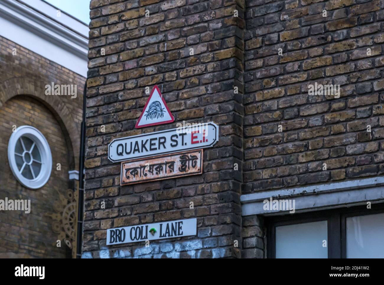 Bilingual street sign in English and Bengali at Quaker St and Brick Lane with Bro Coli Lane, in ...