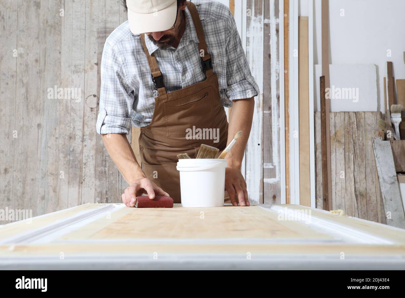 Male carpenter working the wood in carpentry workshop, sanding with ...