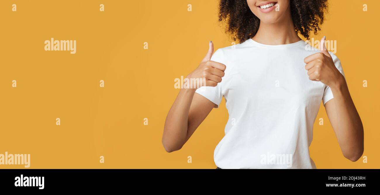 Cropped smiling young african american woman with curly hair in white t ...