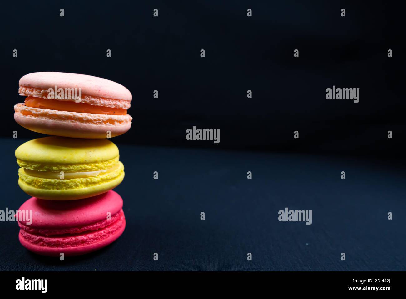 Colourful stack of macaroons isolated on plain black background ...