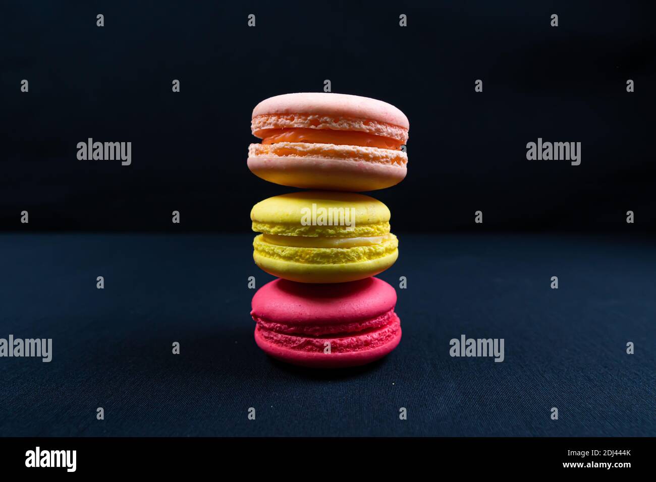 Colourful stack of macaroons isolated on plain black background ...
