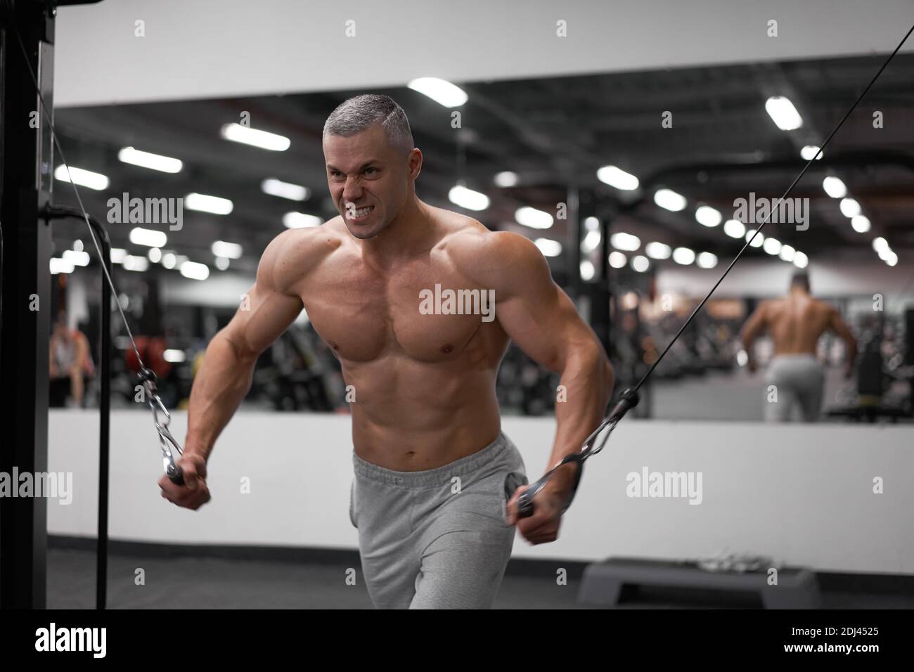 Muscular athletic bodybuilder standing training chest and shoulders ...