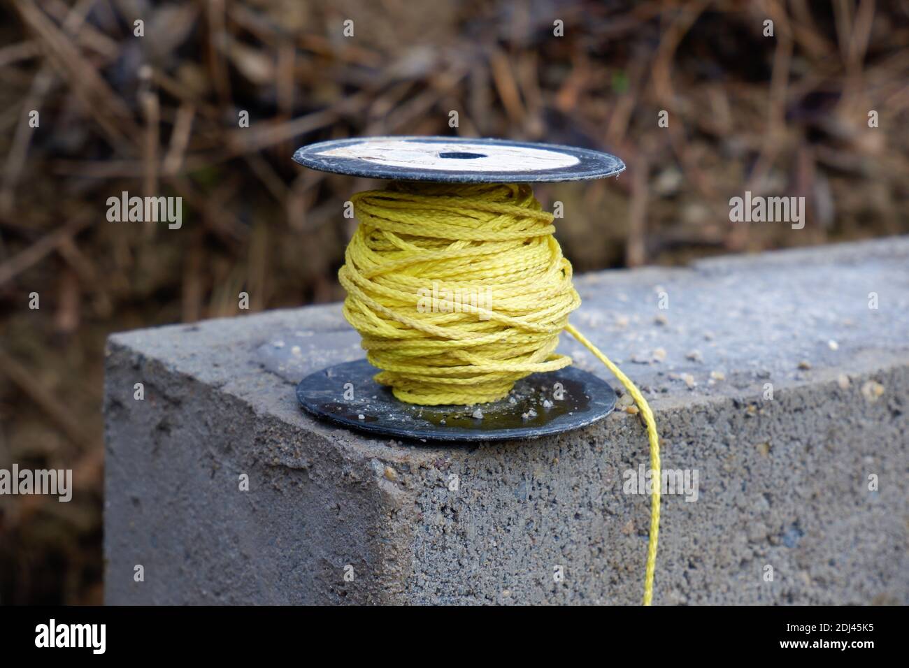 yellow cord string rolls on a metal winder on a concrete wall Stock ...