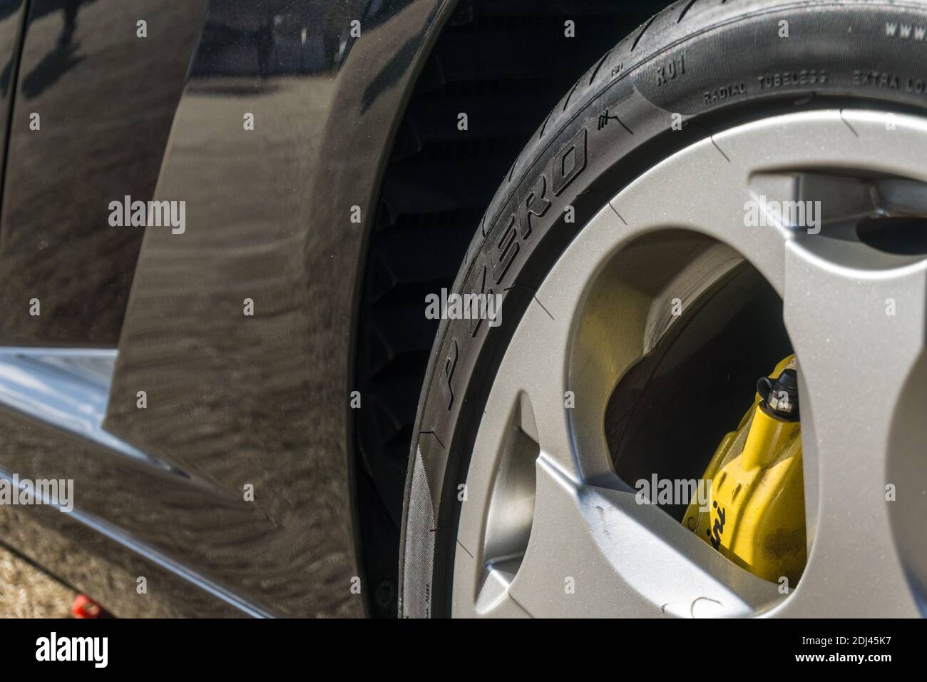Close up detail of the rear wheel, tyre and wheel arch on a metallic ...