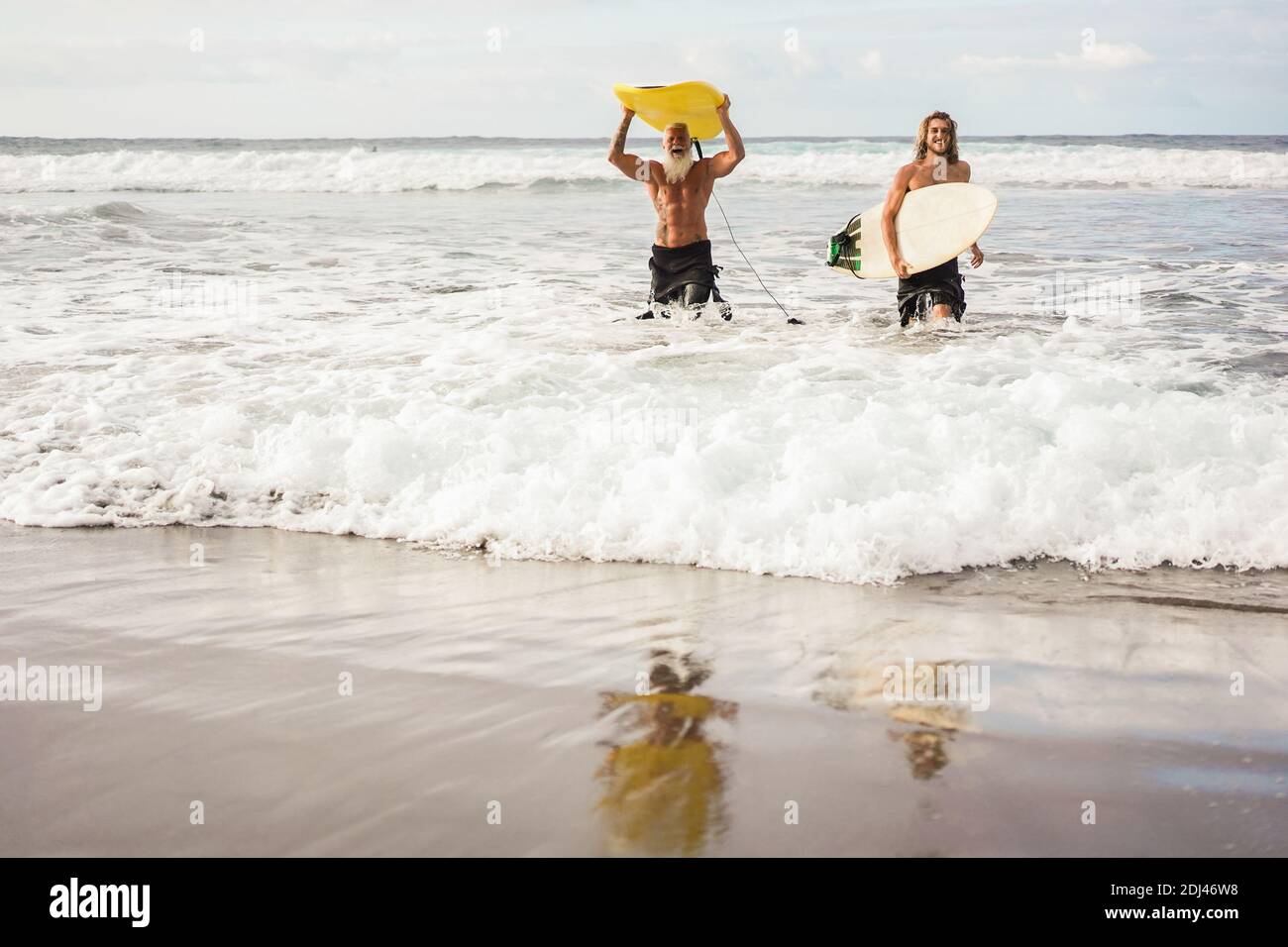 Multigeneration friends having fun while surfing on the island beach ...