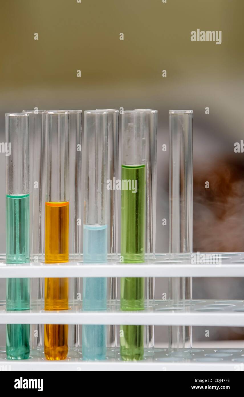 Image of test tubes with colorful solutions are placed in a rack in a ...