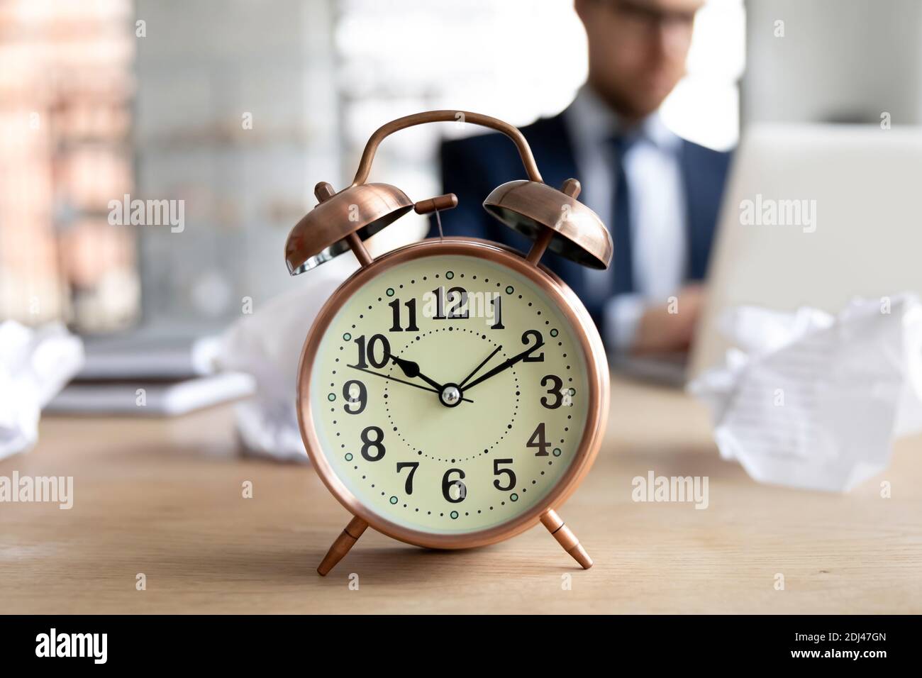 Close up clock standing on desk, busy businessman working Stock Photo ...