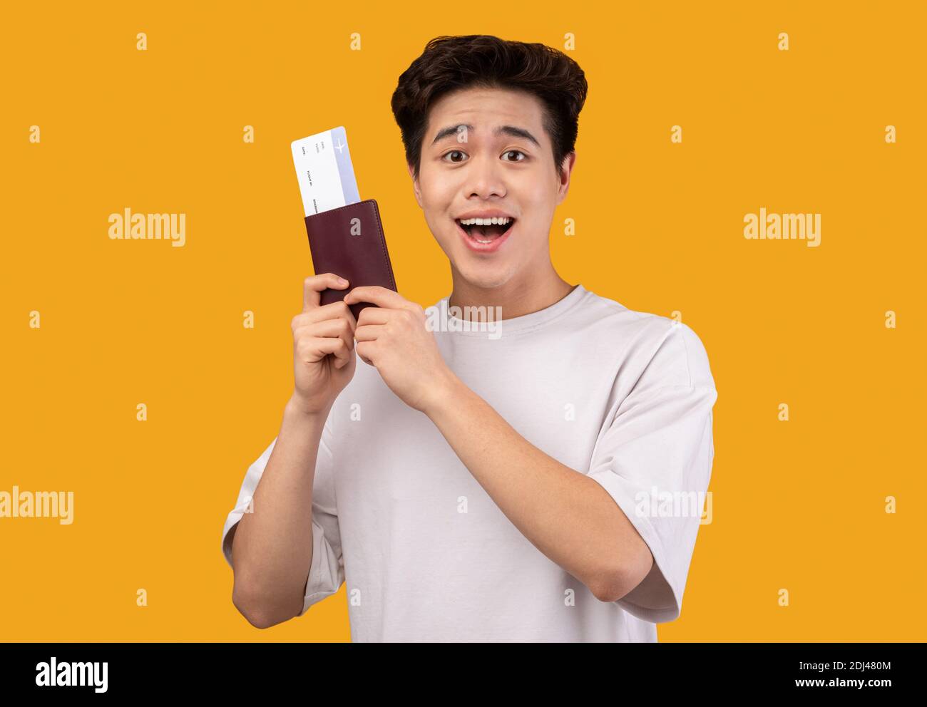 Excited young asian man holding tickets and passport Stock Photo - Alamy