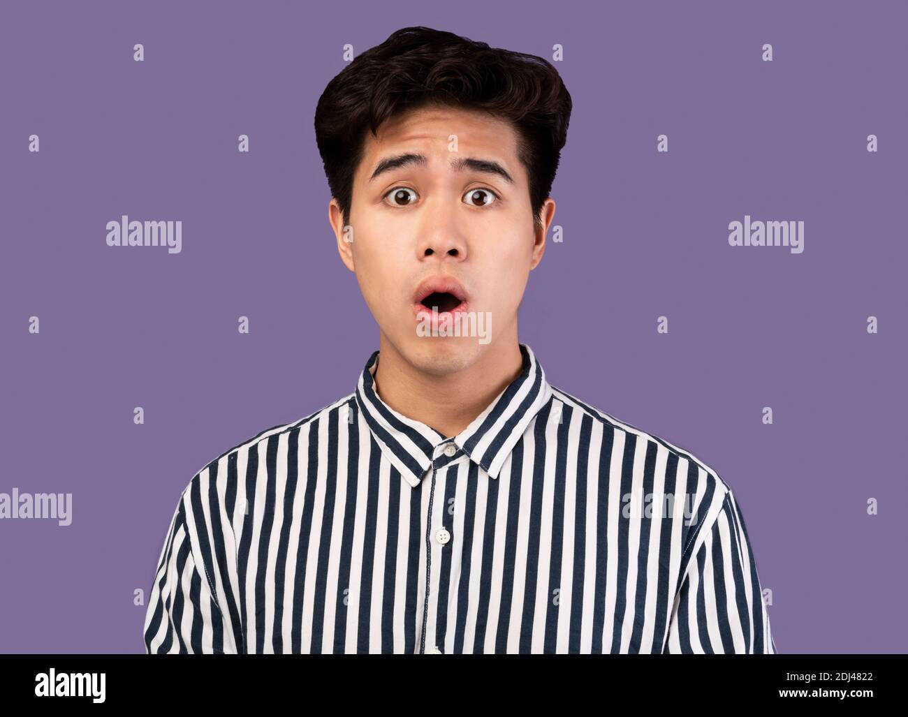 Scared asian guy grimacing, shocked at purple studio Stock Photo - Alamy