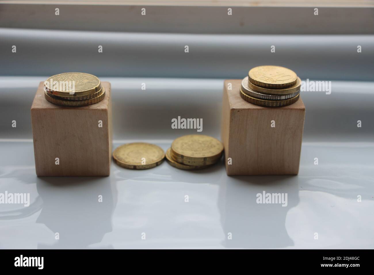 Wooden cubes with coins put into stacks. Business or personal savings ...