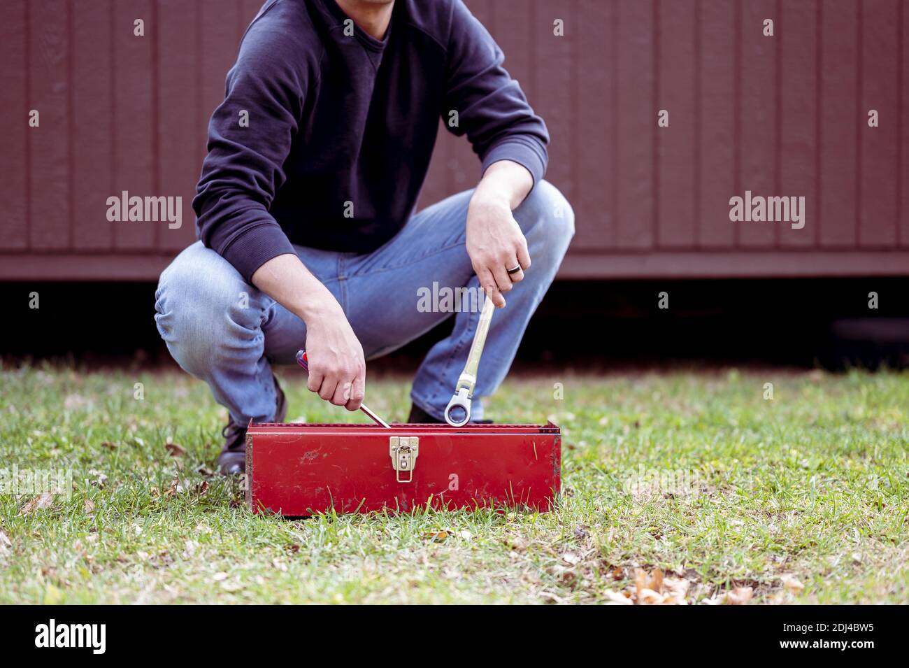 A male mechanic grabbing some tools from a toolbox Stock Photo - Alamy