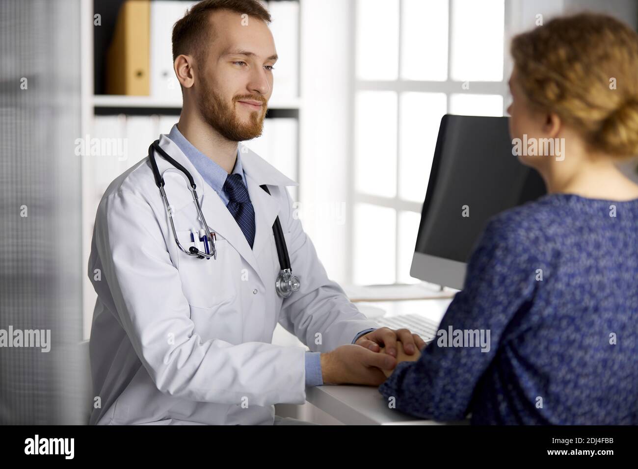 Friendly red-beard doctor reassuring his female patient. Medical ethics ...
