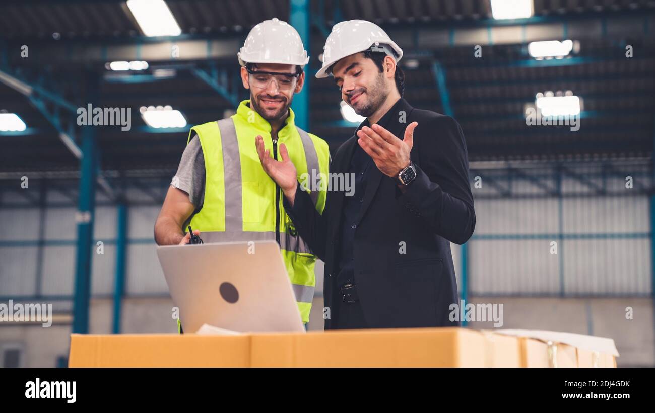 Two factory workers working and discussing manufacturing plan in the ...