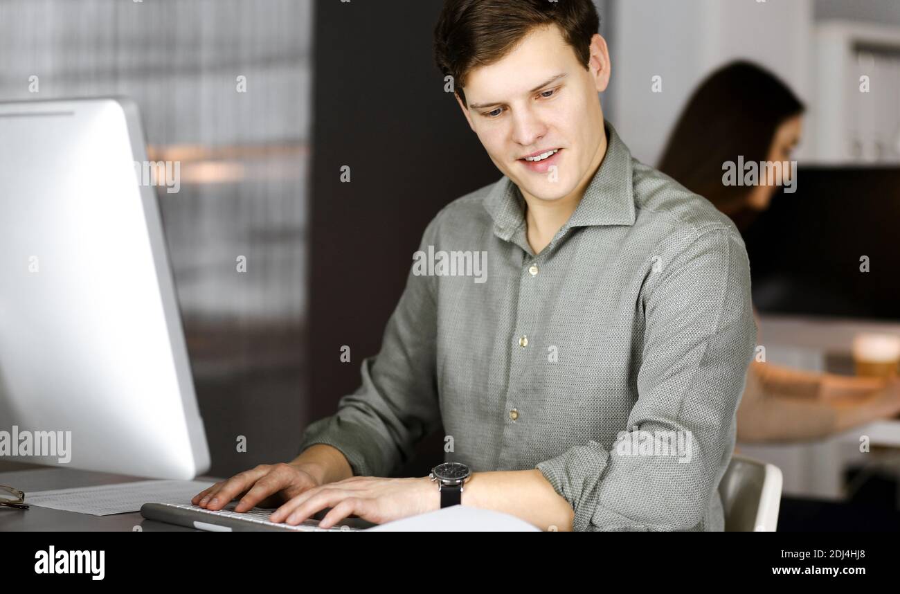 Young businessman and programmer in a green shirt is checking a ...