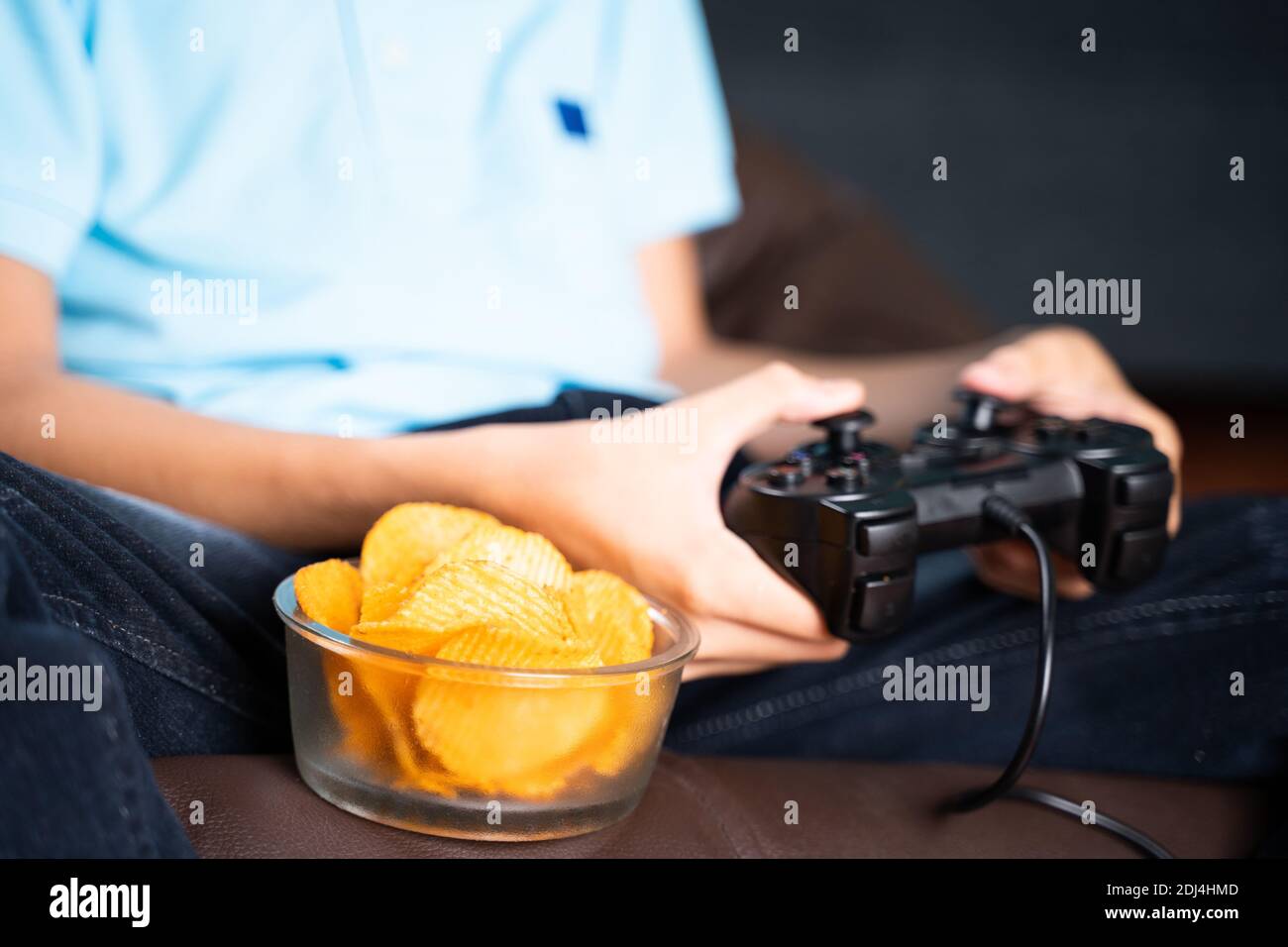 Selective focus on snacks, kid playing video game and placing chips to ...