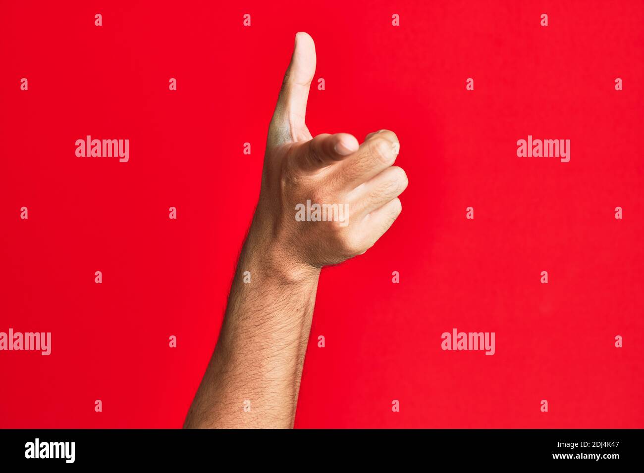 Arm of caucasian white young man over red isolated background pointing ...