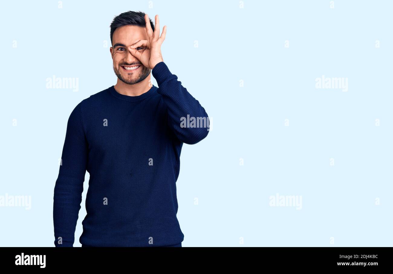 Young handsome man wearing casual clothes doing ok gesture with hand ...