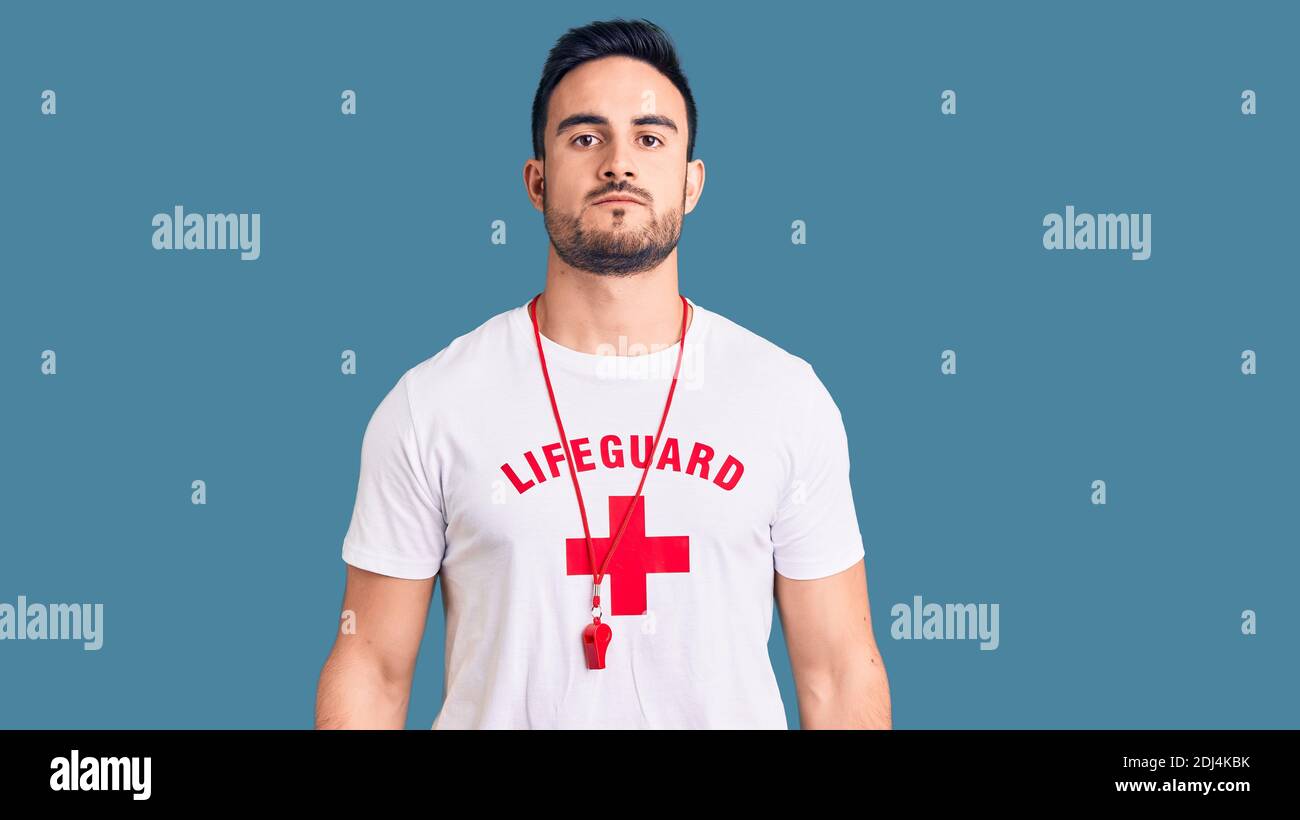 Young handsome man wearing lifeguard uniform relaxed with serious ...